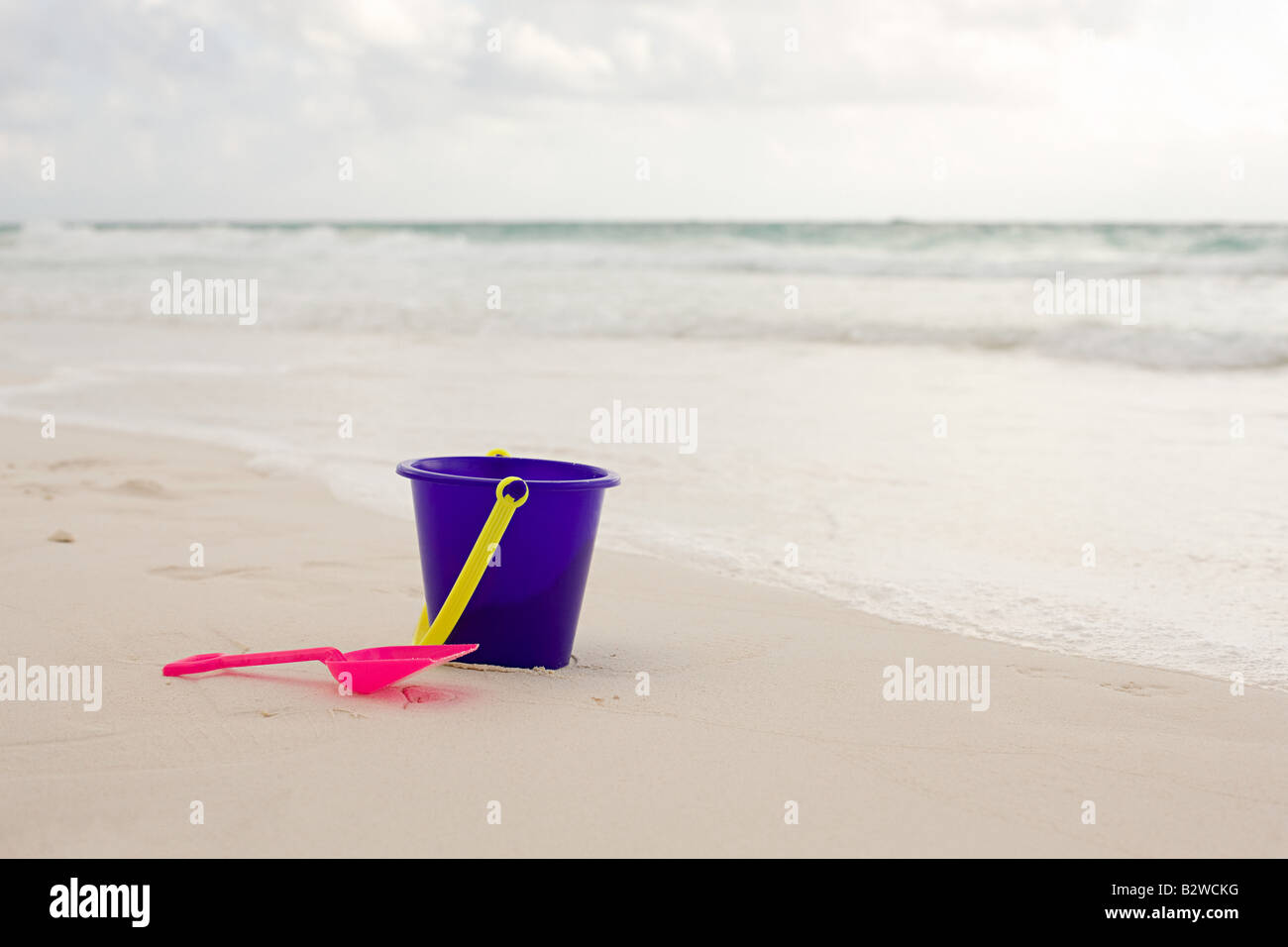Bucket and spade on a beach Stock Photo - Alamy