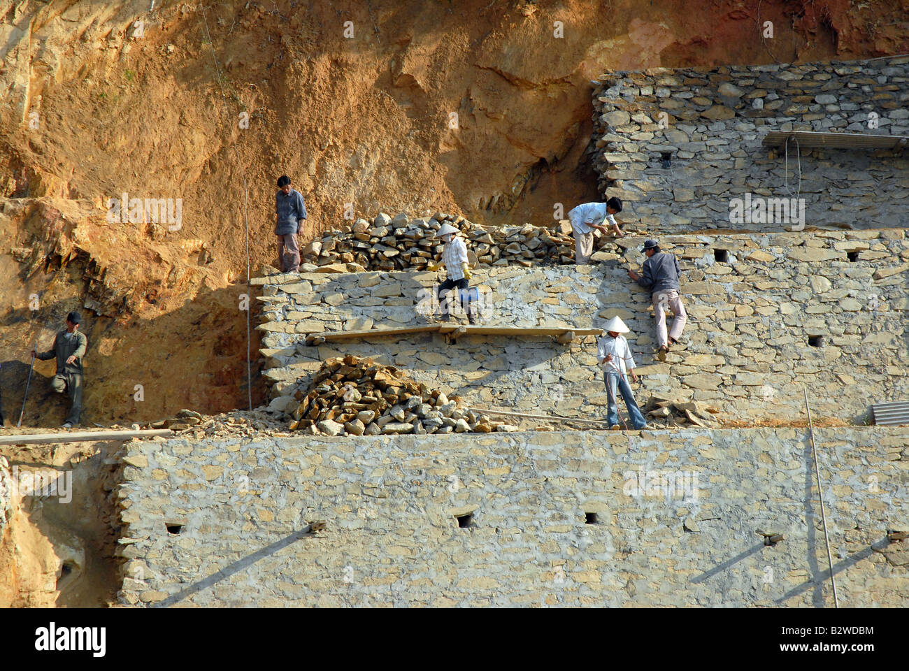 Construction workers building a retaining wall by manual labor Stock ...