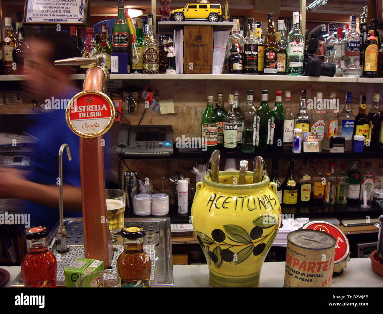 Typical scene of a bar and barman in a tapas bar in Seville, Andalucia ...