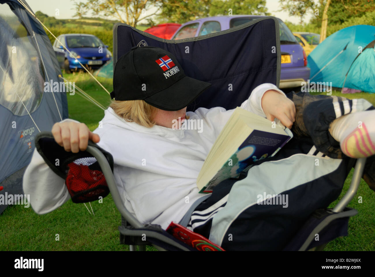 Girl reading in a campsite Stock Photo - Alamy