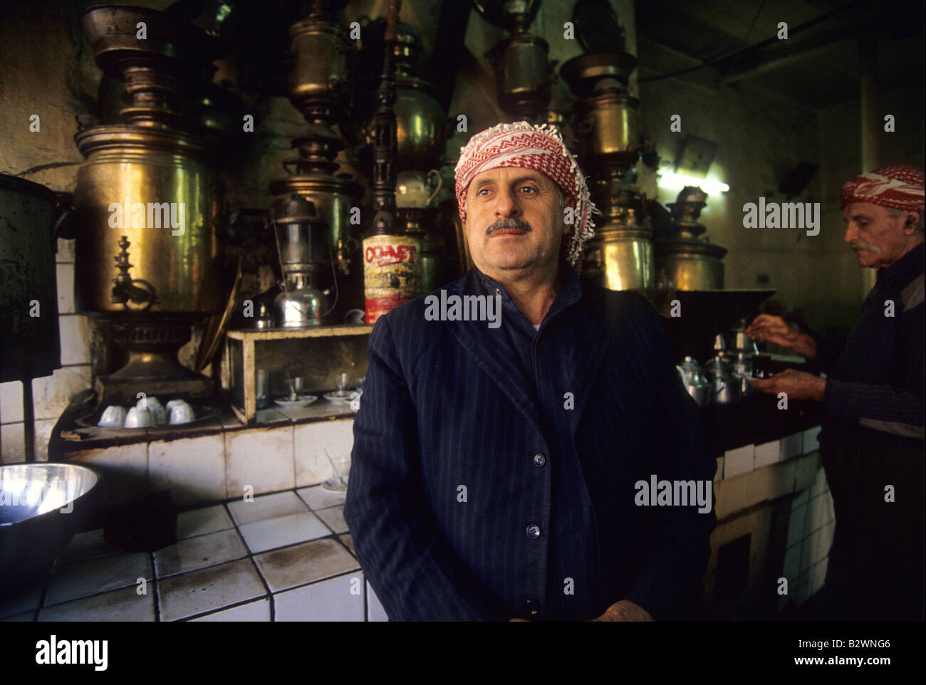 The owner of a Baghdad Iraq tea shop stands near his hot water bukharas ...