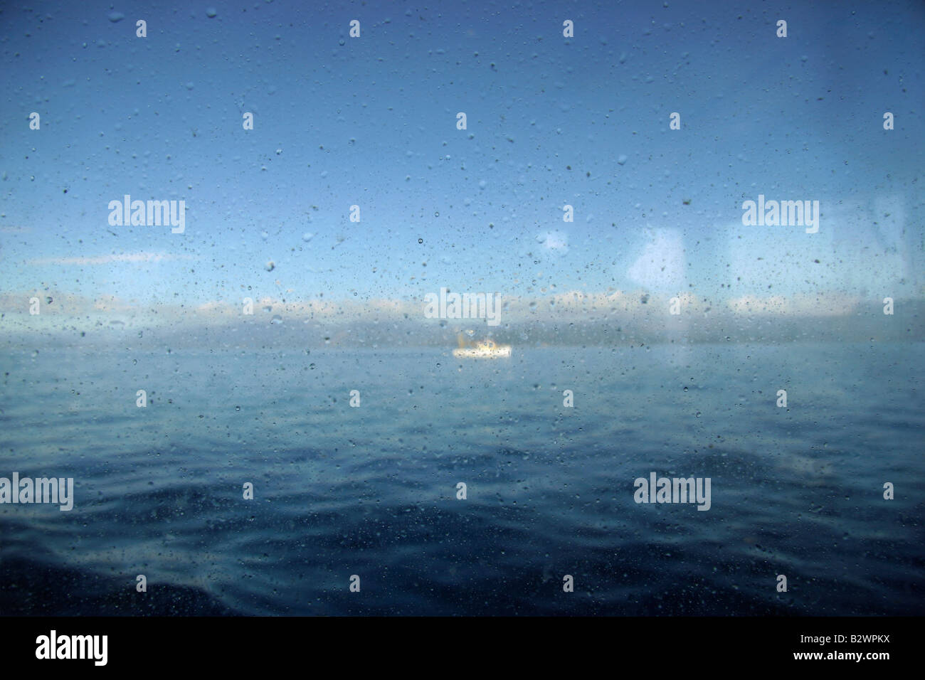 Fishing trawler seen through the splashed window of another in the ...
