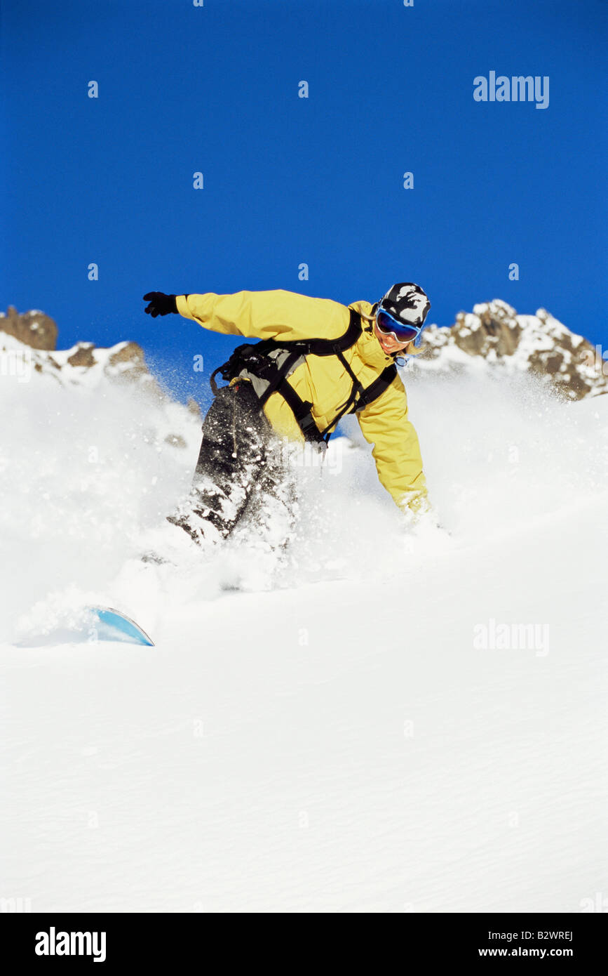 Snowboarder coming down hill smiling Stock Photo - Alamy