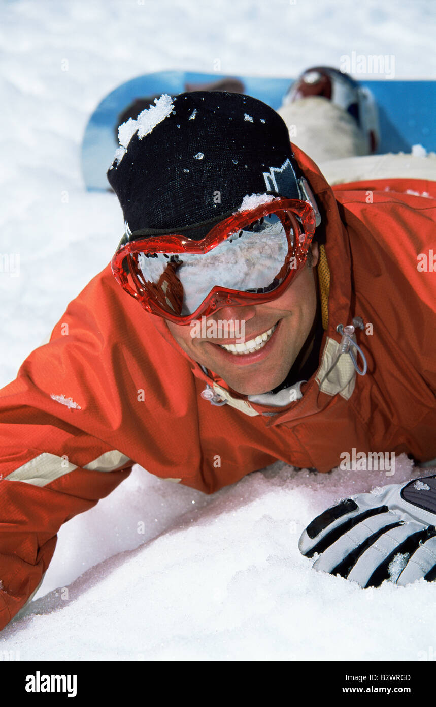 Snowboarder lying on hill smiling (selective focus Stock Photo - Alamy