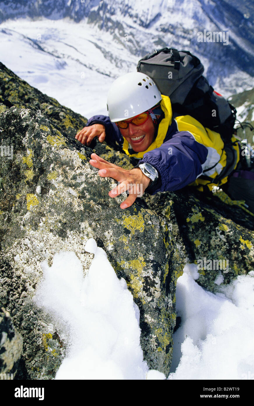 Mountain climber coming up snowy mountain smiling (selective focus ...