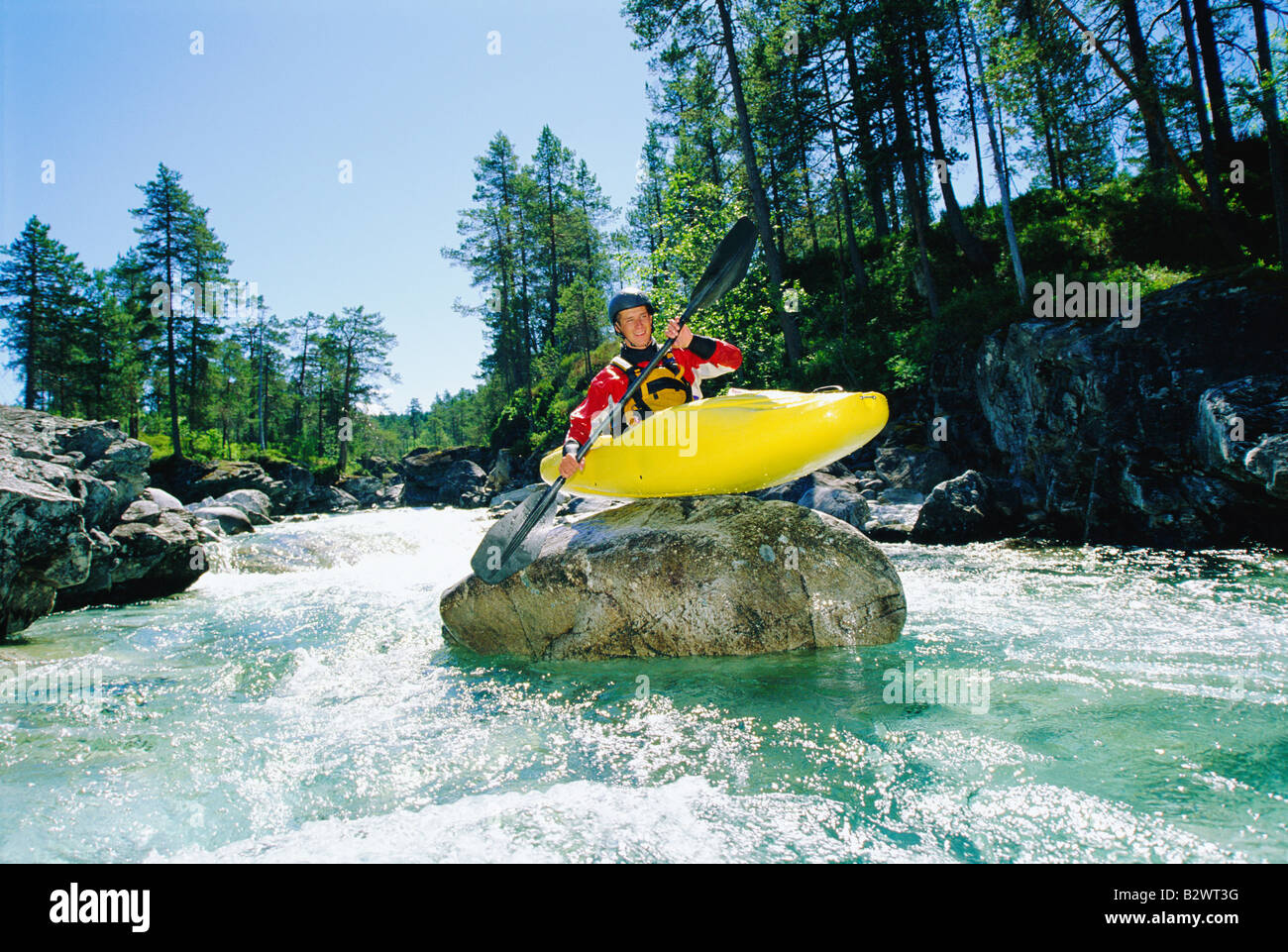 Kayaker on top of rock in rapids smiling Stock Photo - Alamy