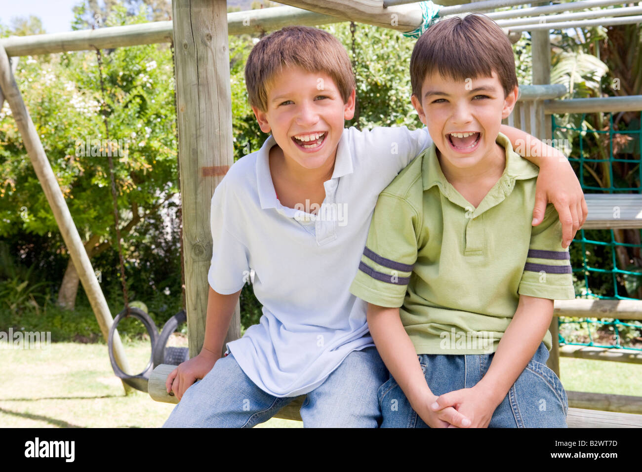 Two young male friends at a playground smiling Stock Photo - Alamy