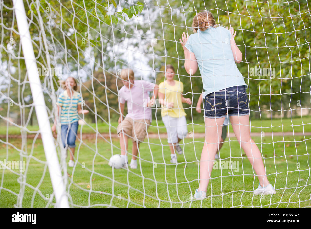 Five young friends playing soccer Stock Photo - Alamy