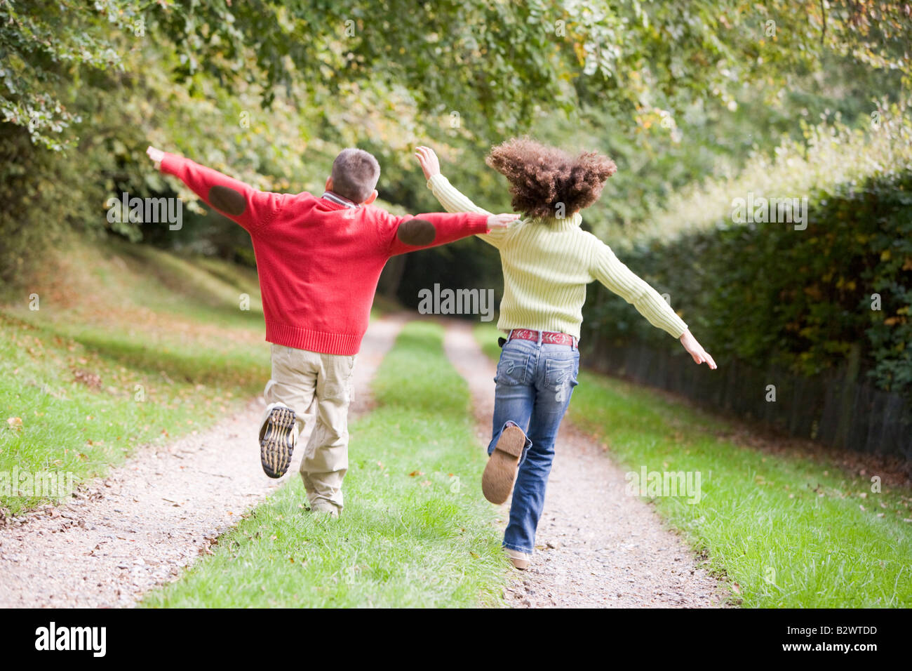 Two young friends running on a path outdoors Stock Photo - Alamy