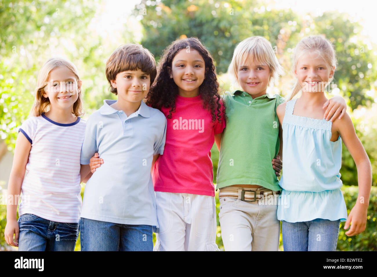 Five young friends standing outdoors smiling Stock Photo - Alamy