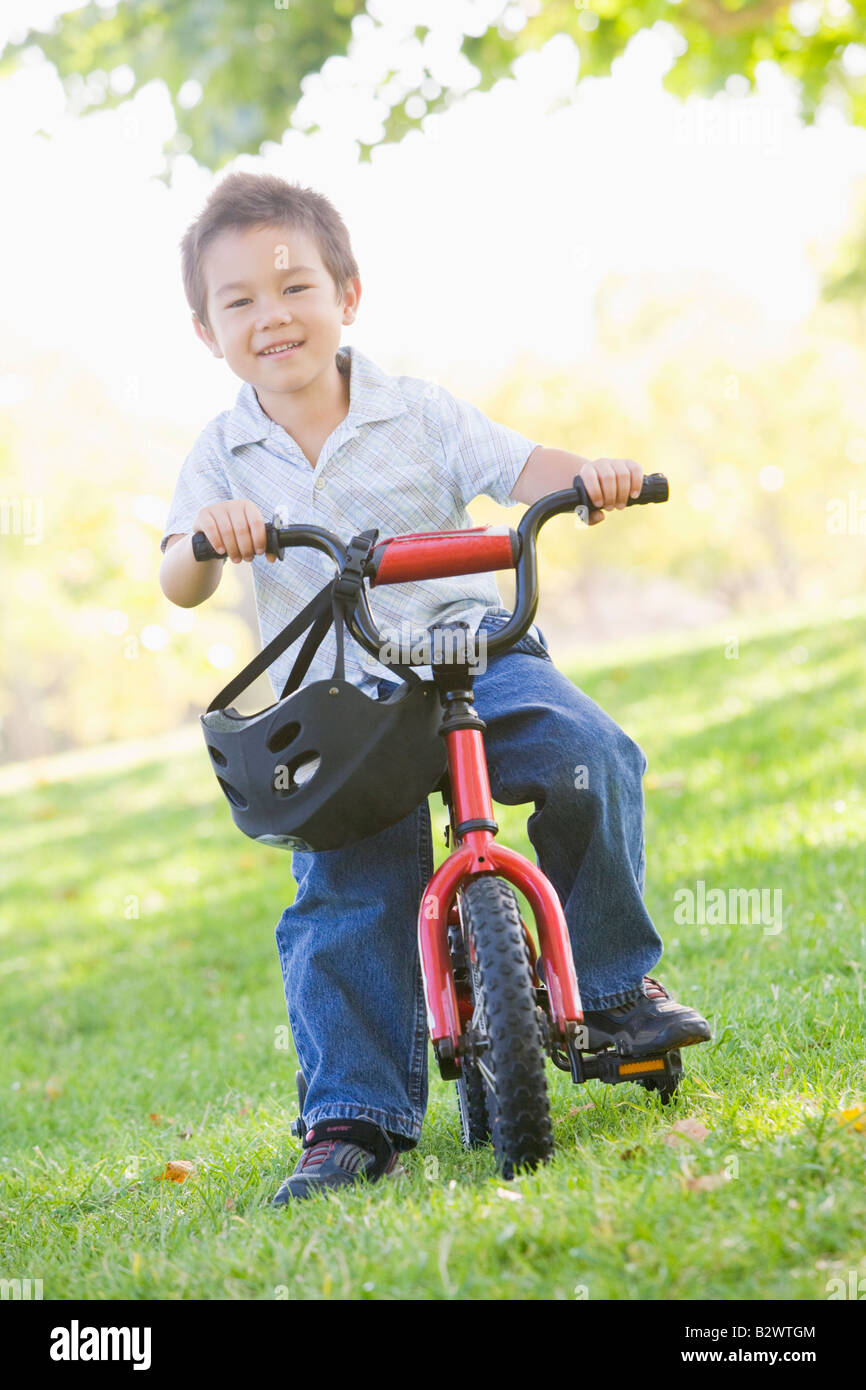 Young boy on bicycle outdoors smiling Stock Photo - Alamy