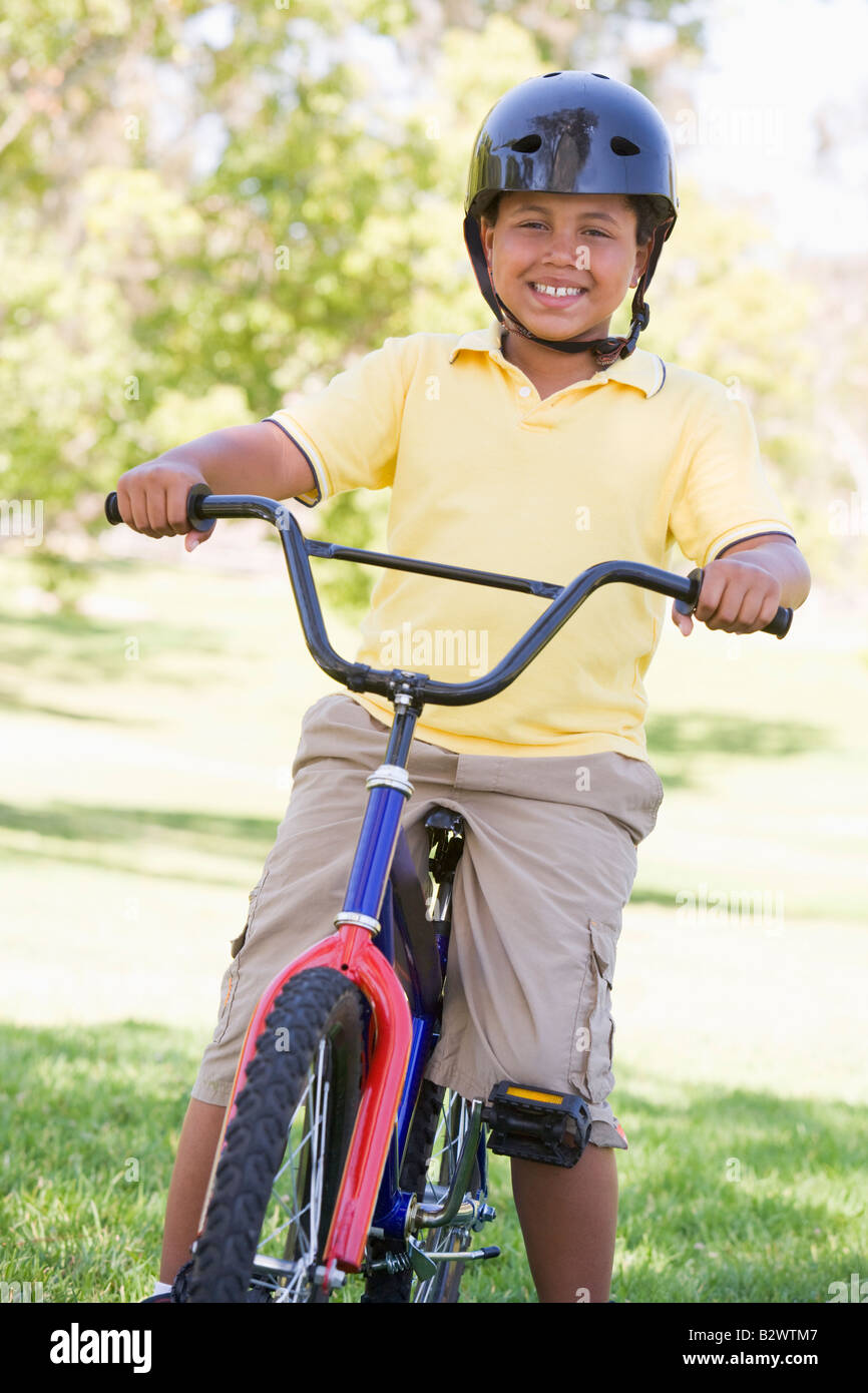Young boy on bicycle outdoors smiling Stock Photo - Alamy