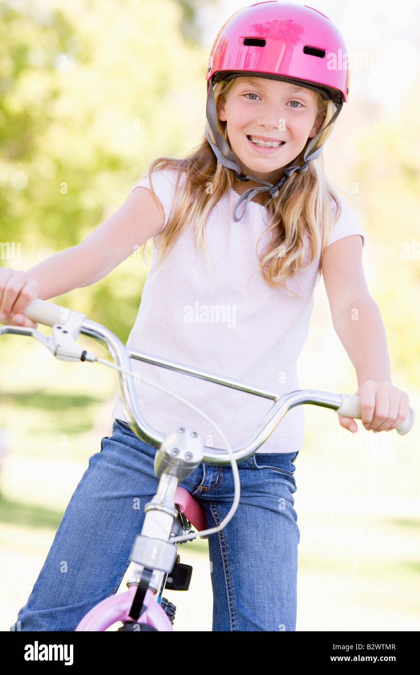 Young girl on bicycle outdoors smiling Stock Photo - Alamy