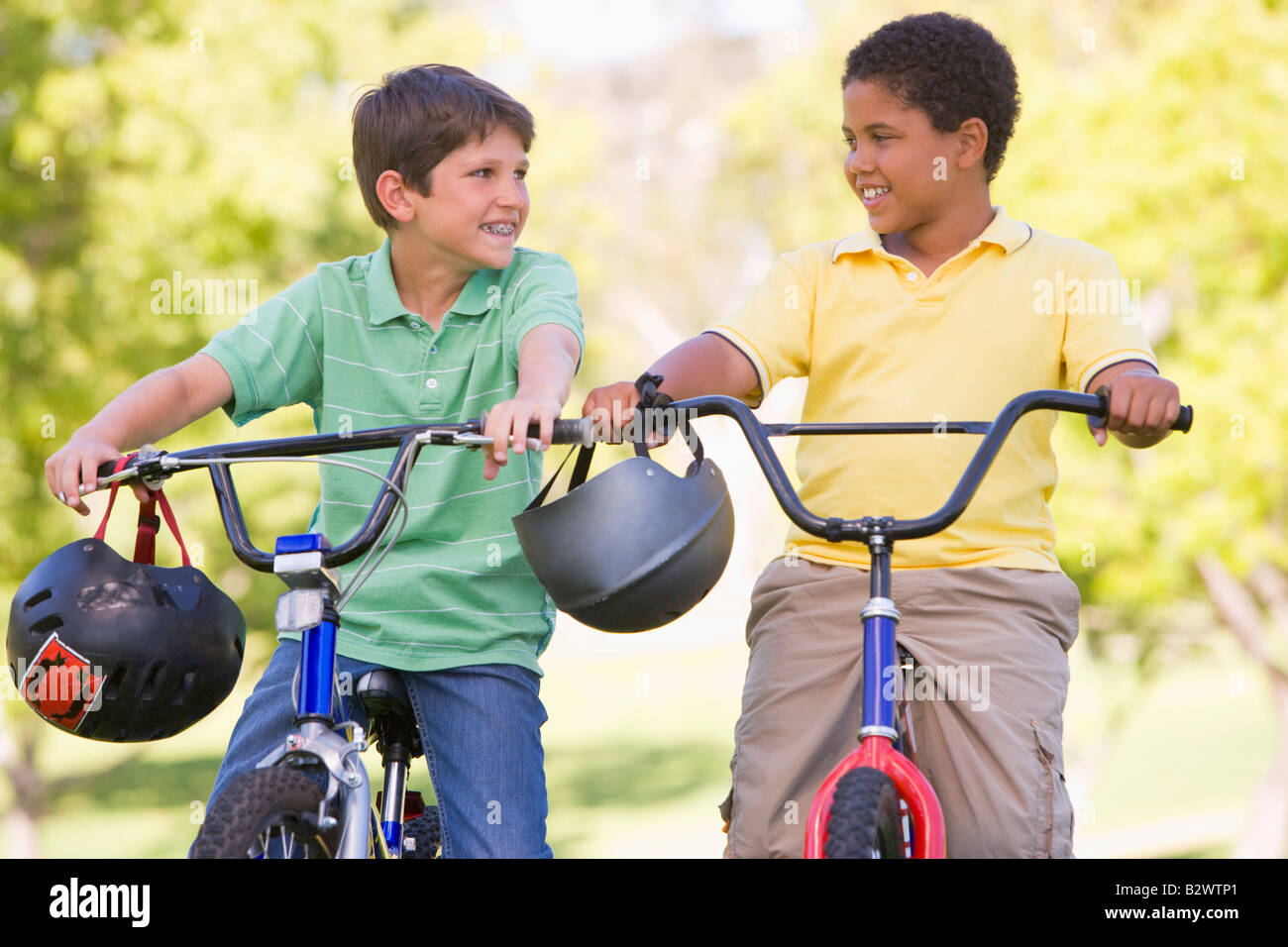Two young boys on bicycles outdoors smiling Stock Photo - Alamy