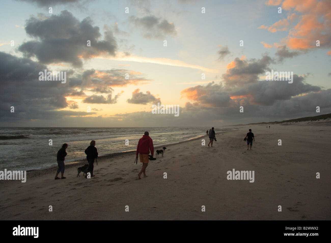 Holidaymakers on a beach at sunset Stock Photo - Alamy