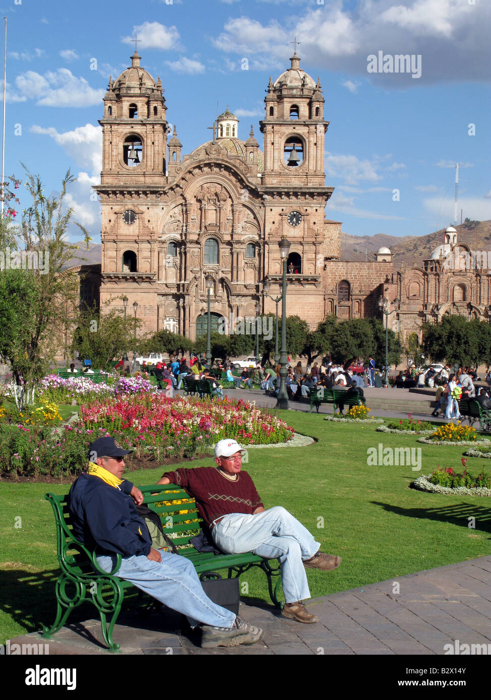 2 men sit on a bench in the main square in Cusco, Peru, South America ...