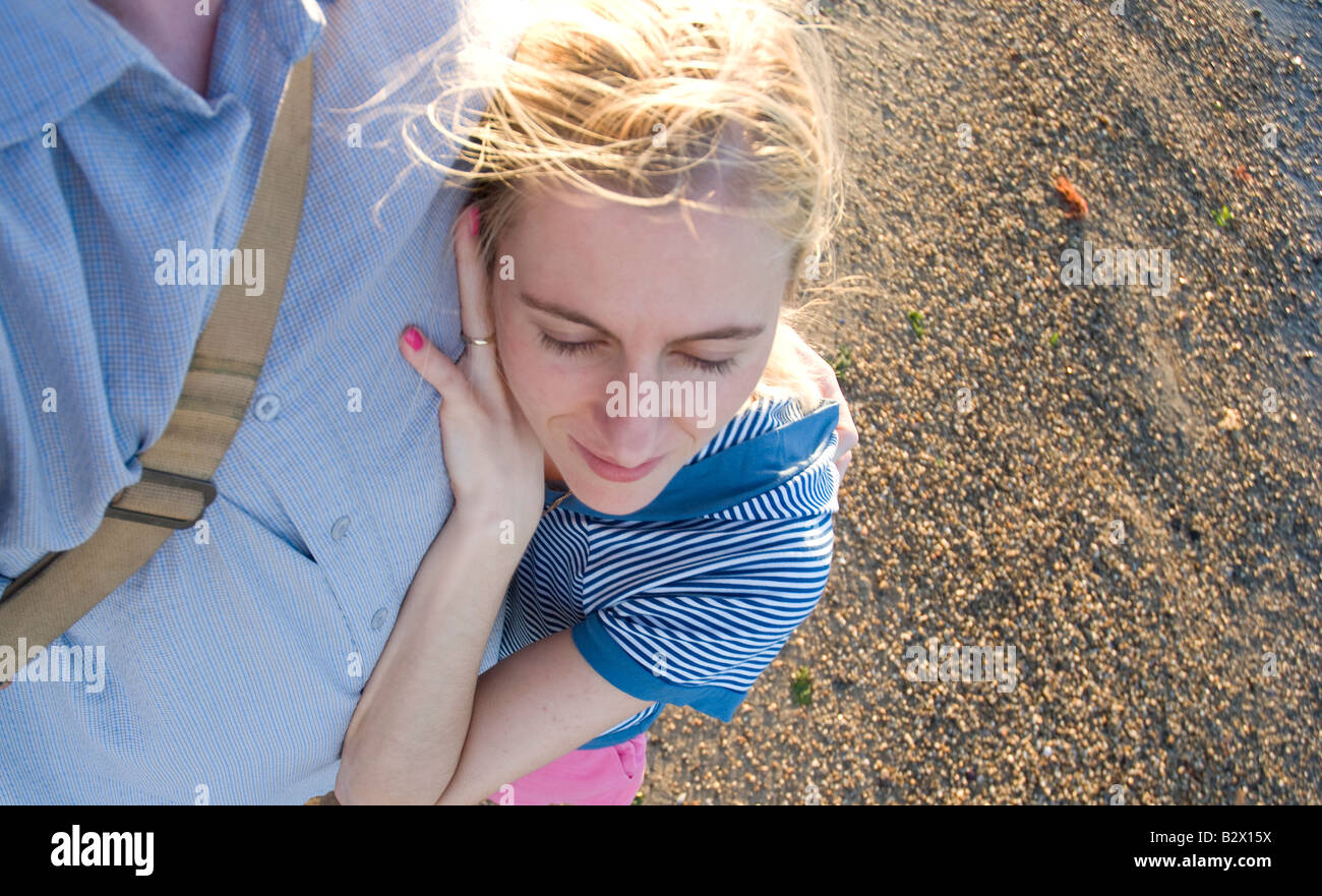 an ambiguous shot of a young couple at the beach, as the lady rests her ...