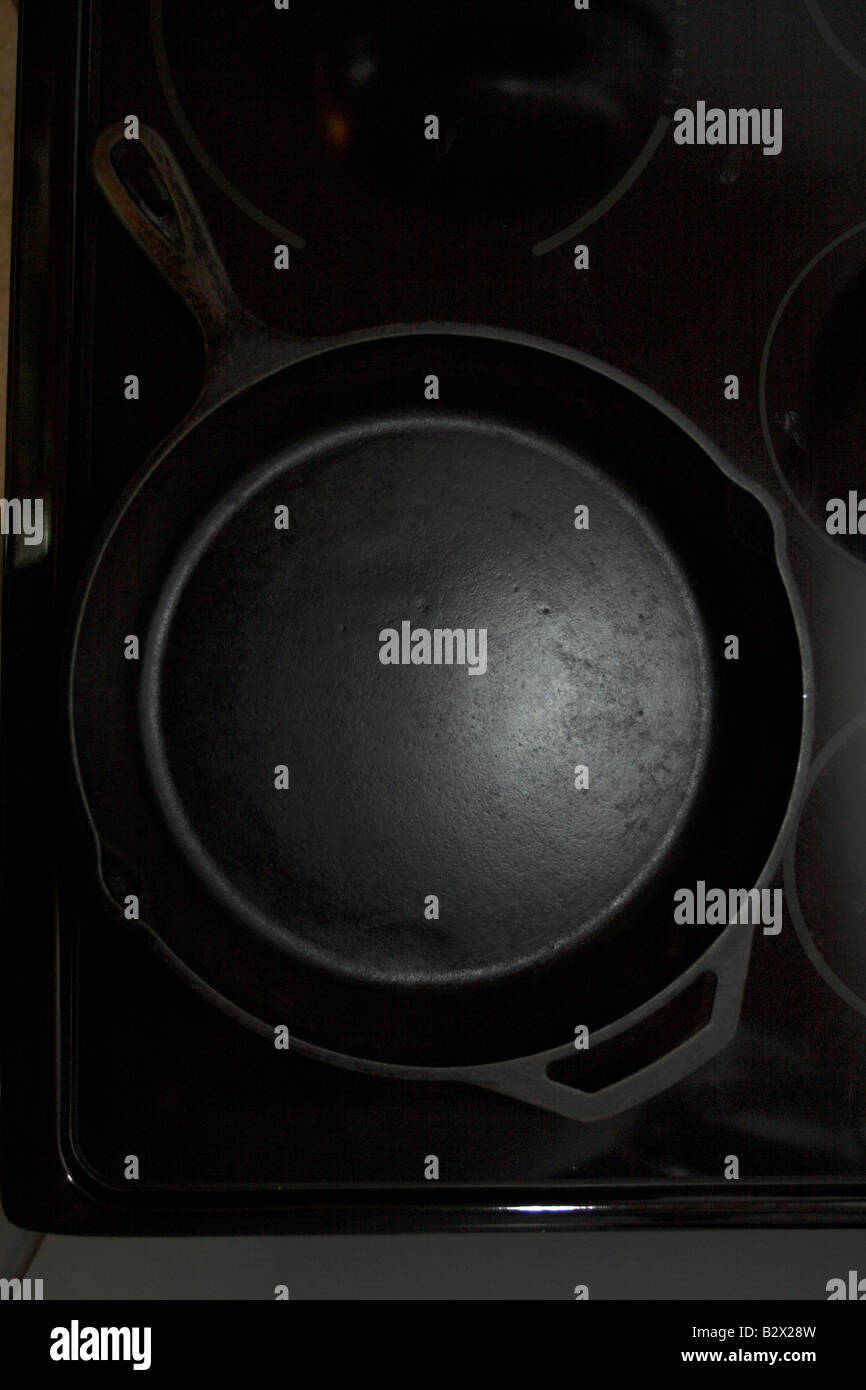 From directly above, a black, cured iron skillet on black Stock Photo ...