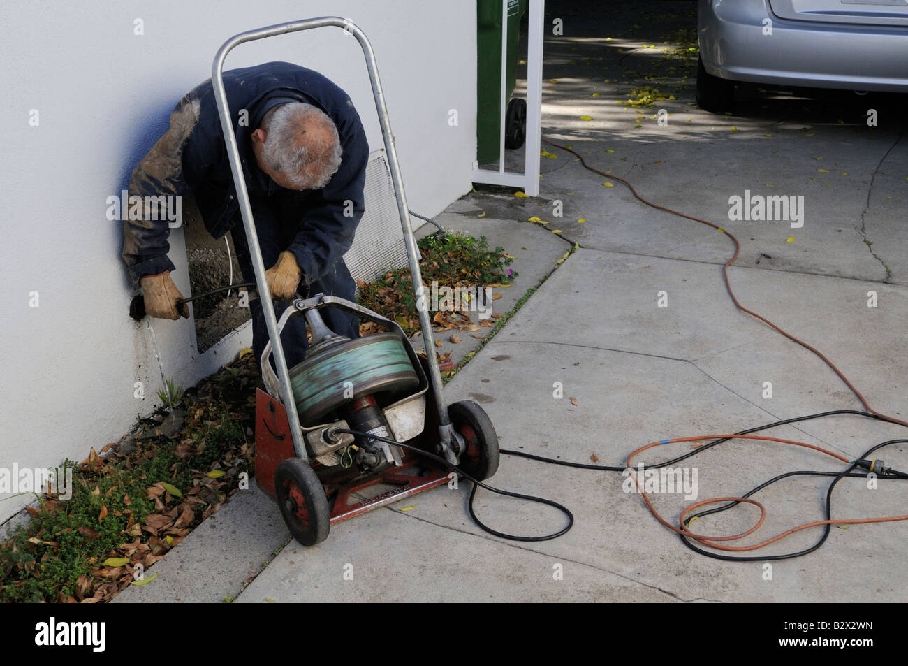 Plumber working with motorized equipment on pipe system Stock Photo - Alamy