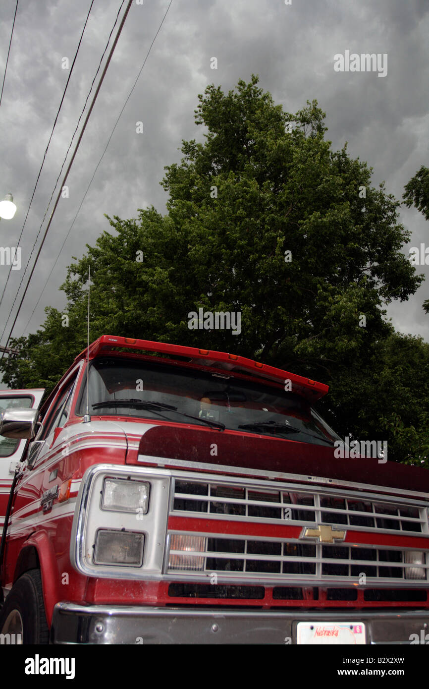 Front grille of a full size Chevy van with looming severe thunderstorm ...