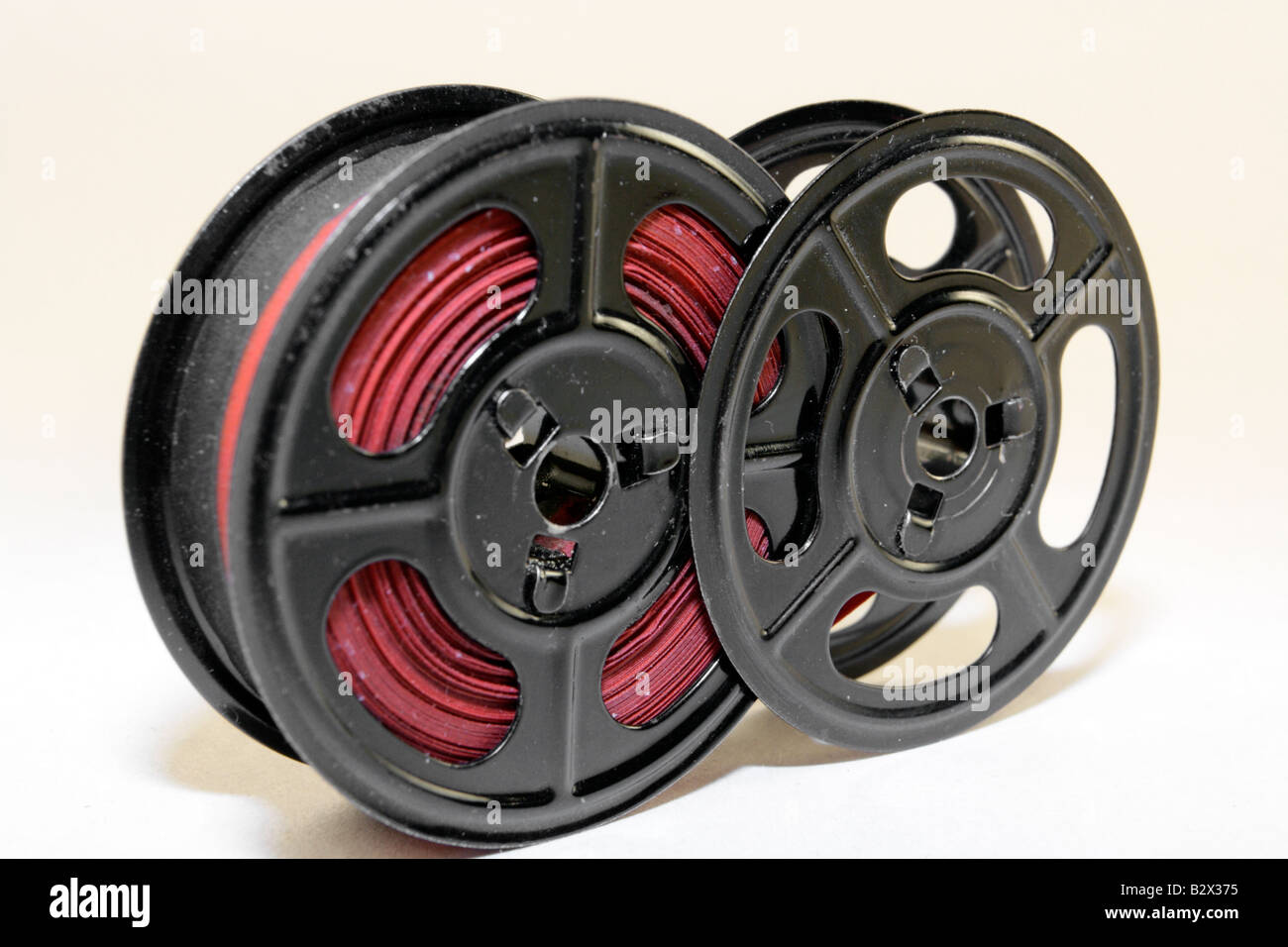Paired black steel typewriter ribbon spools with red and black ribbon ...