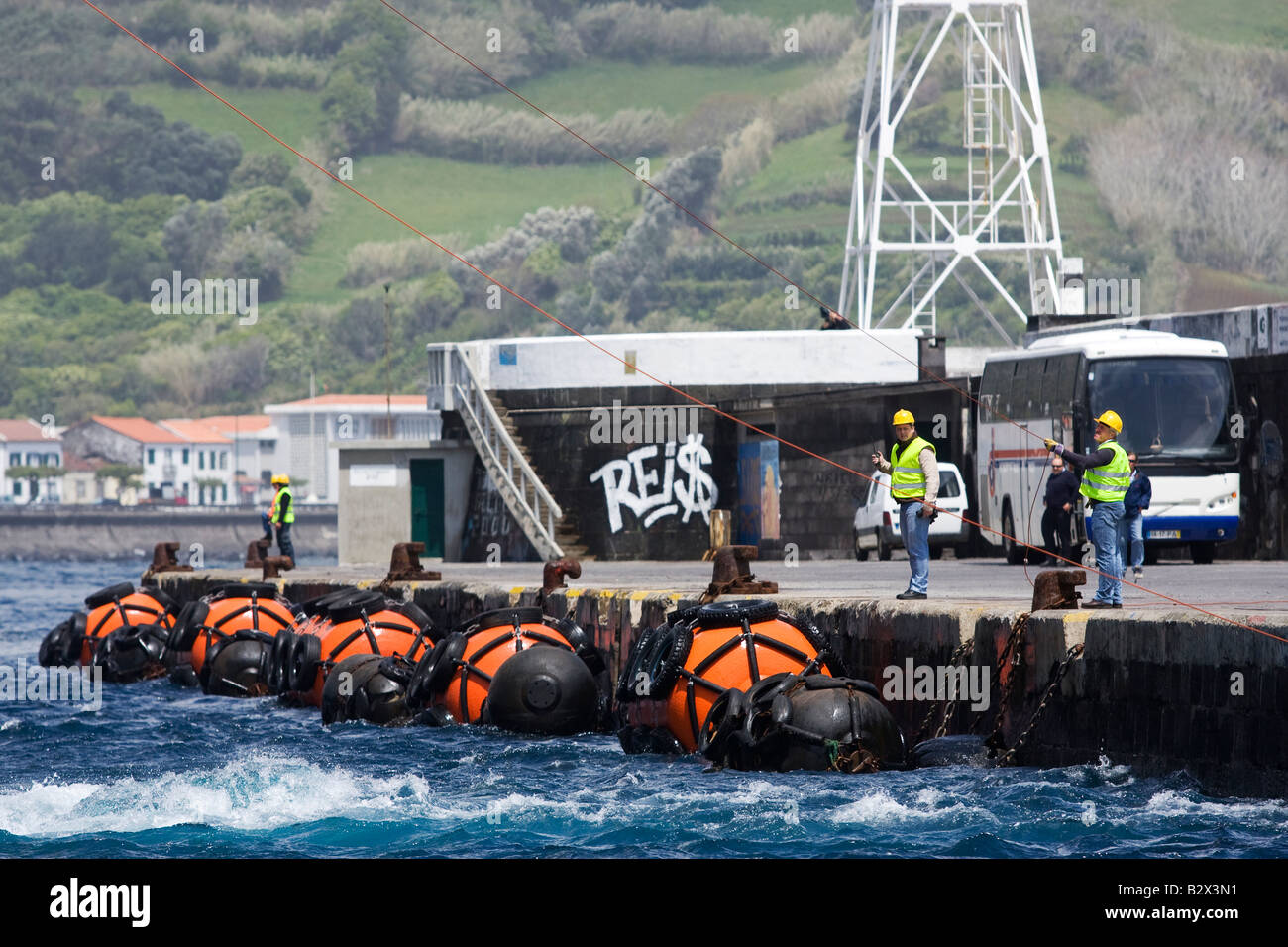 Municipal road workers and supervisor install part of a new storm drain ...