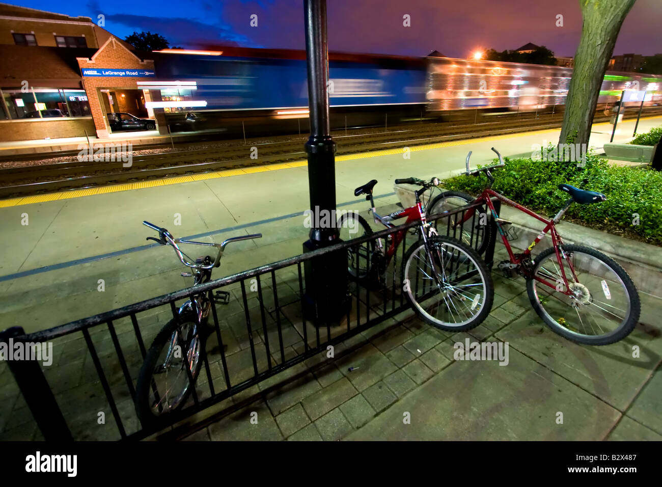 A commuter train speeds into the station at night Stock Photo - Alamy