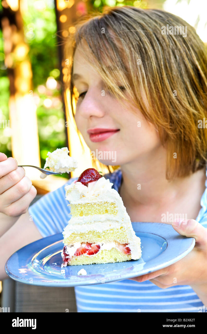 Teenage girl eating a piece of strawberry cake Stock Photo - Alamy