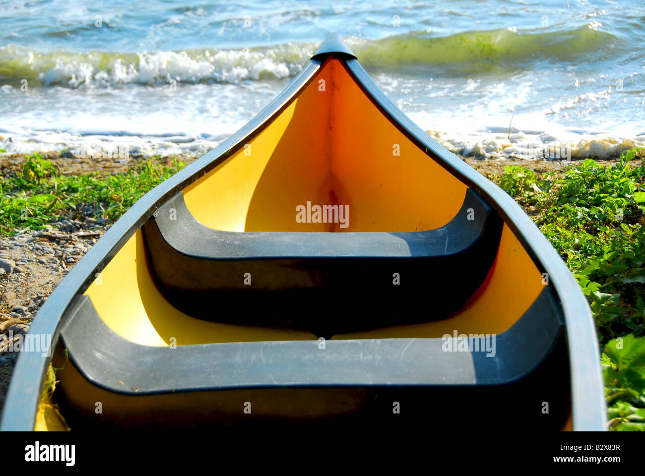 Yellow canoe on lake shore Stock Photo - Alamy