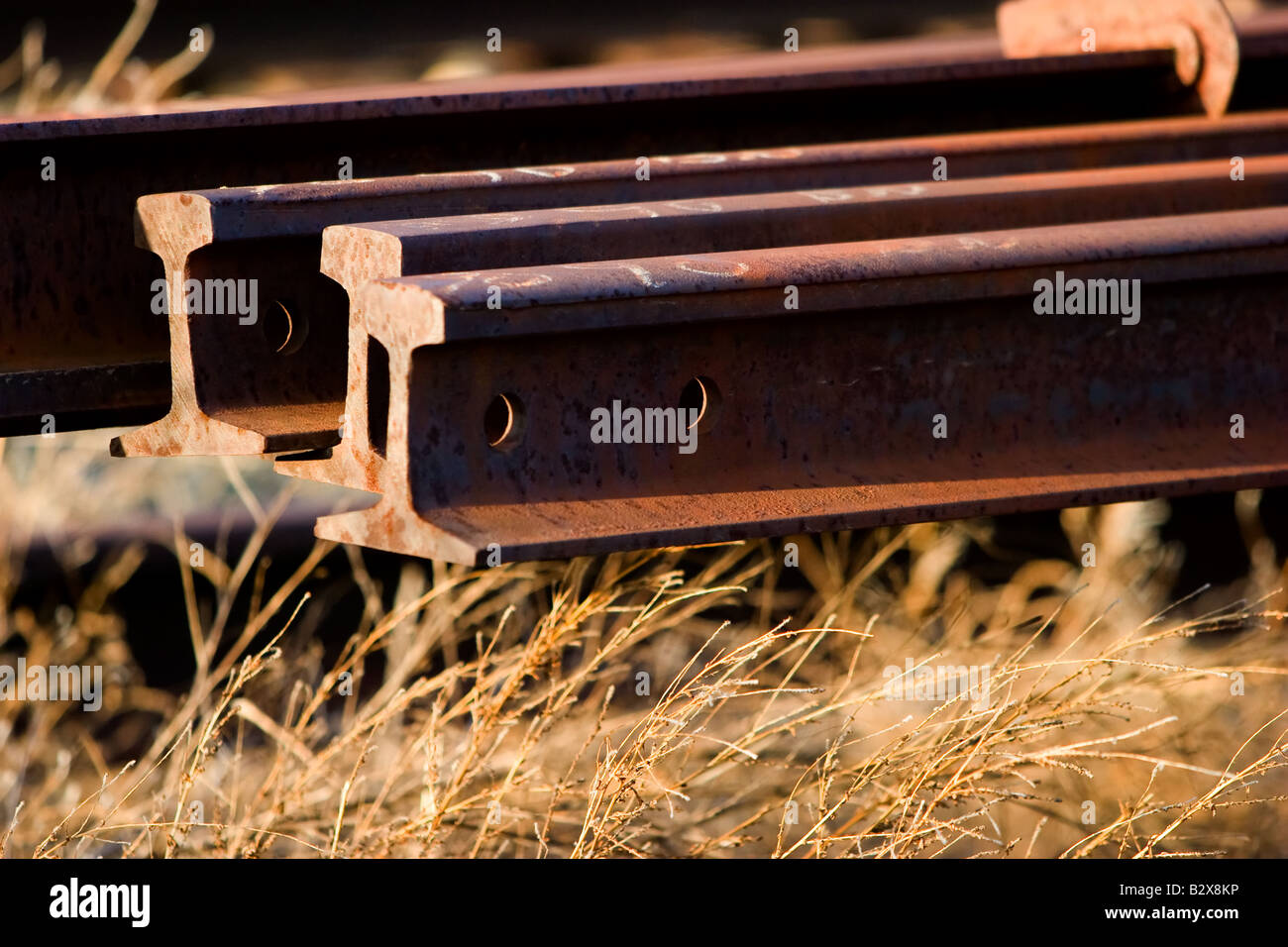A pile of rusty rails sits unused in a rail yard Stock Photo - Alamy