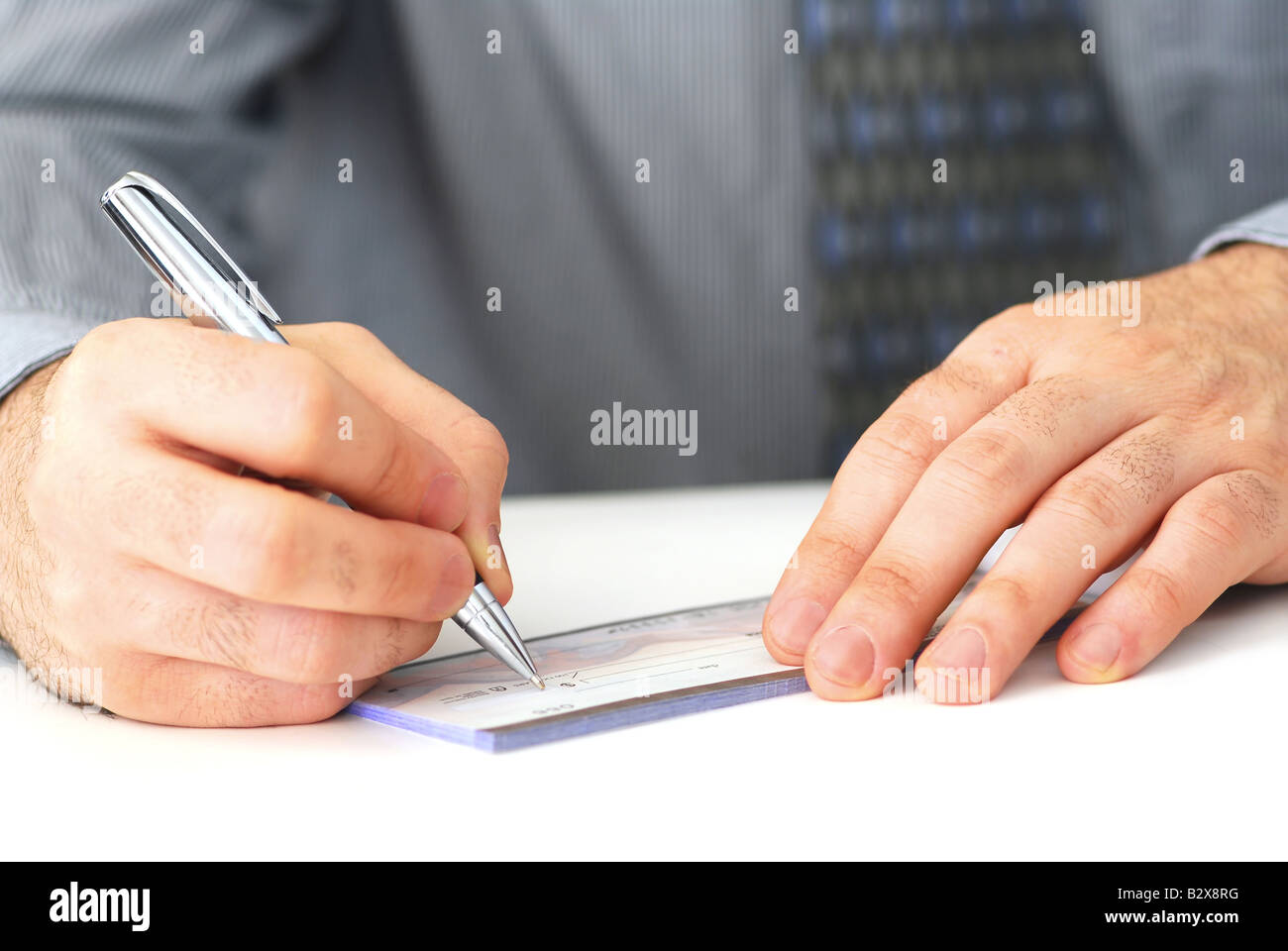 Closeup of man s hands writing a cheque Stock Photo - Alamy