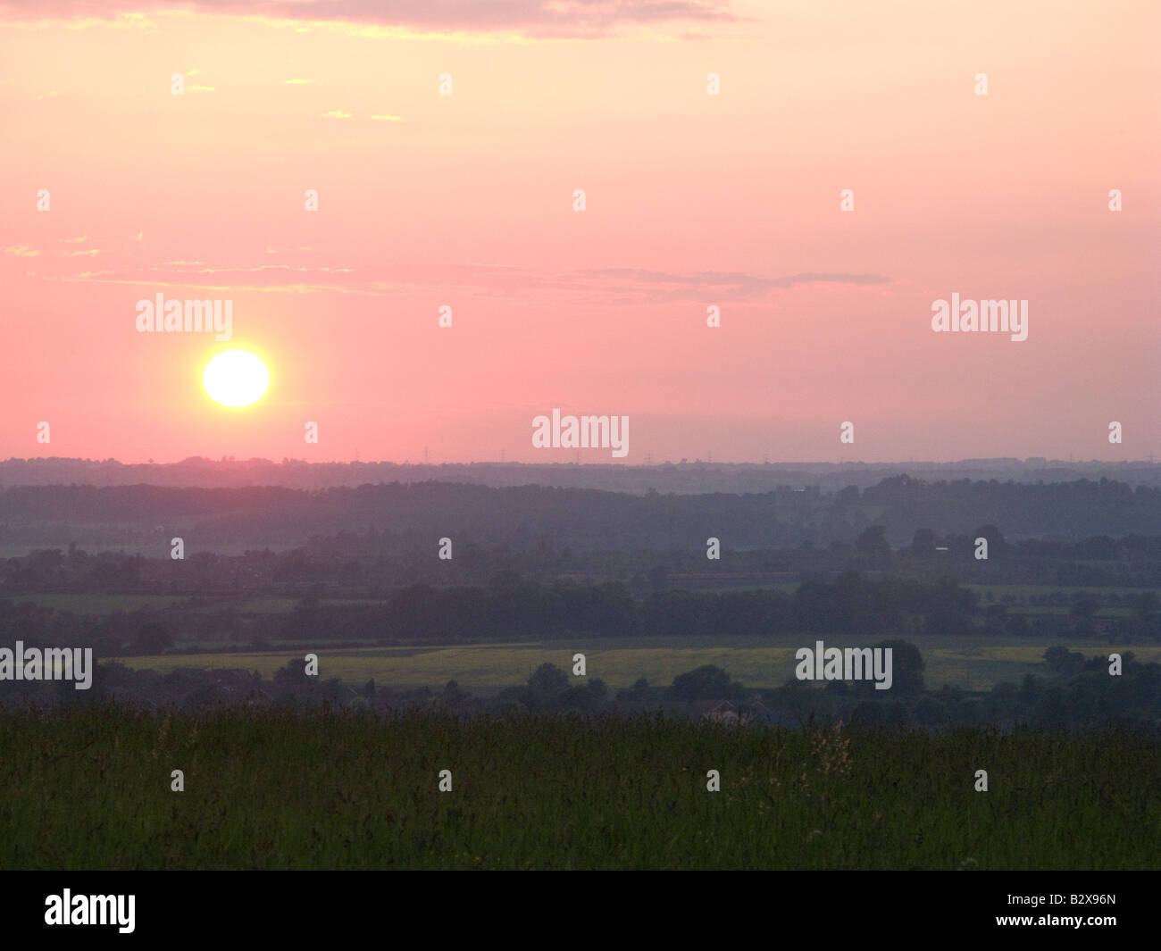 Richly coloured warm summer sunset over Aylesbury Vale showing layers ...