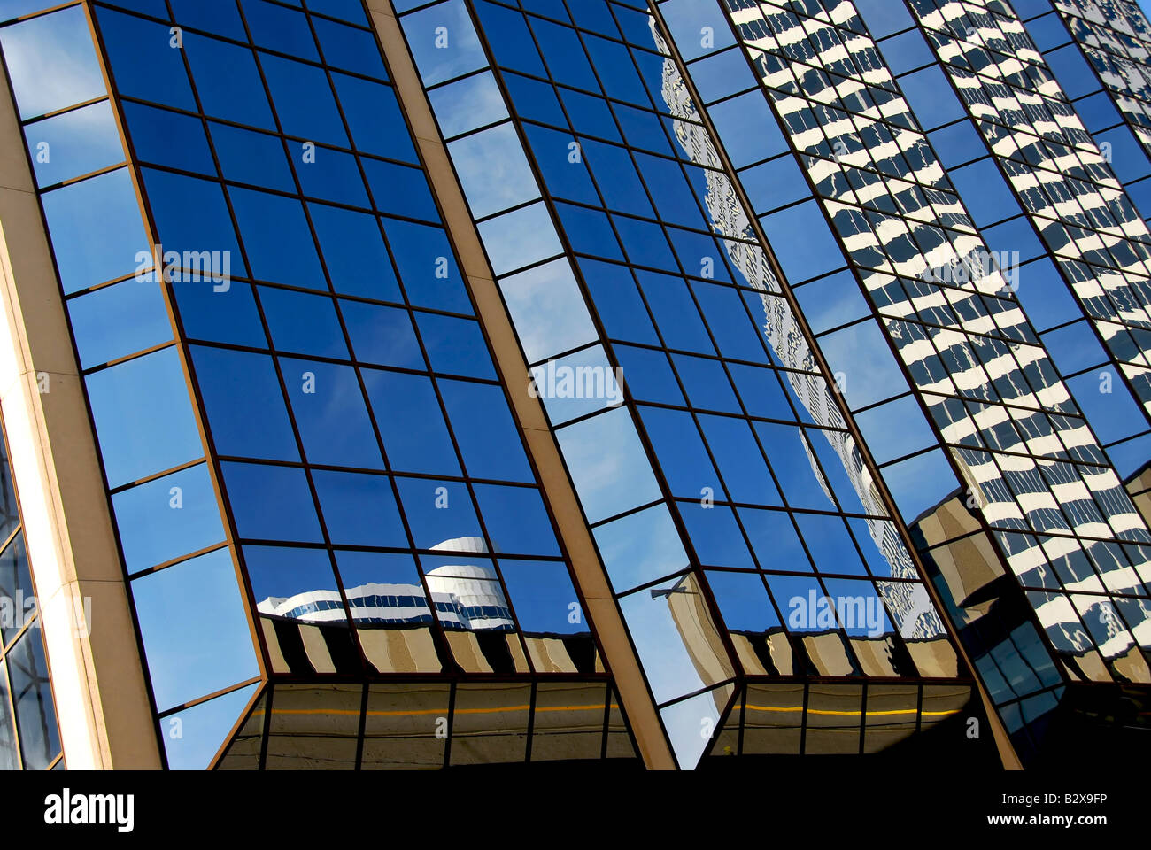 Reflections in a blue mirror glass wall of a skyscraper abstract ...