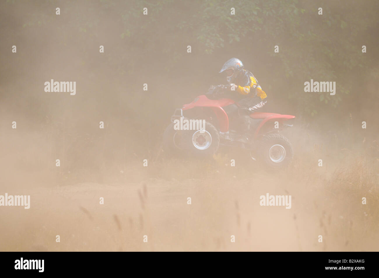 ATV captured in mid-air through clouds of dust Stock Photo - Alamy