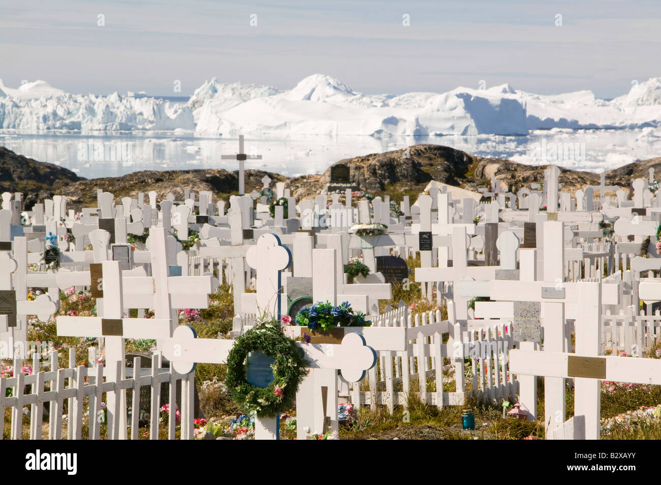 An Inuit burial graveyard at Ilulissat on Greenland with ice bergs from ...