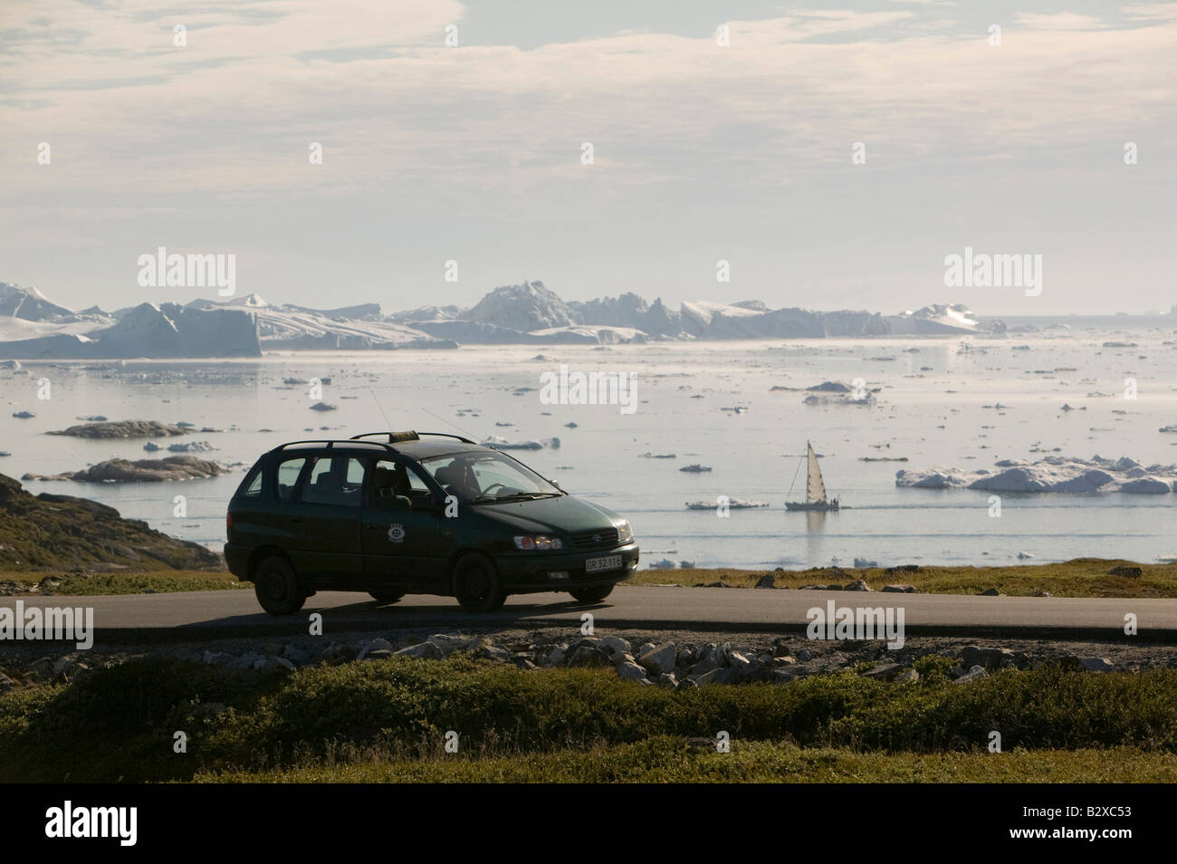 A car in front of icebergs from the Ilulissat ice fjord on Greenland ...