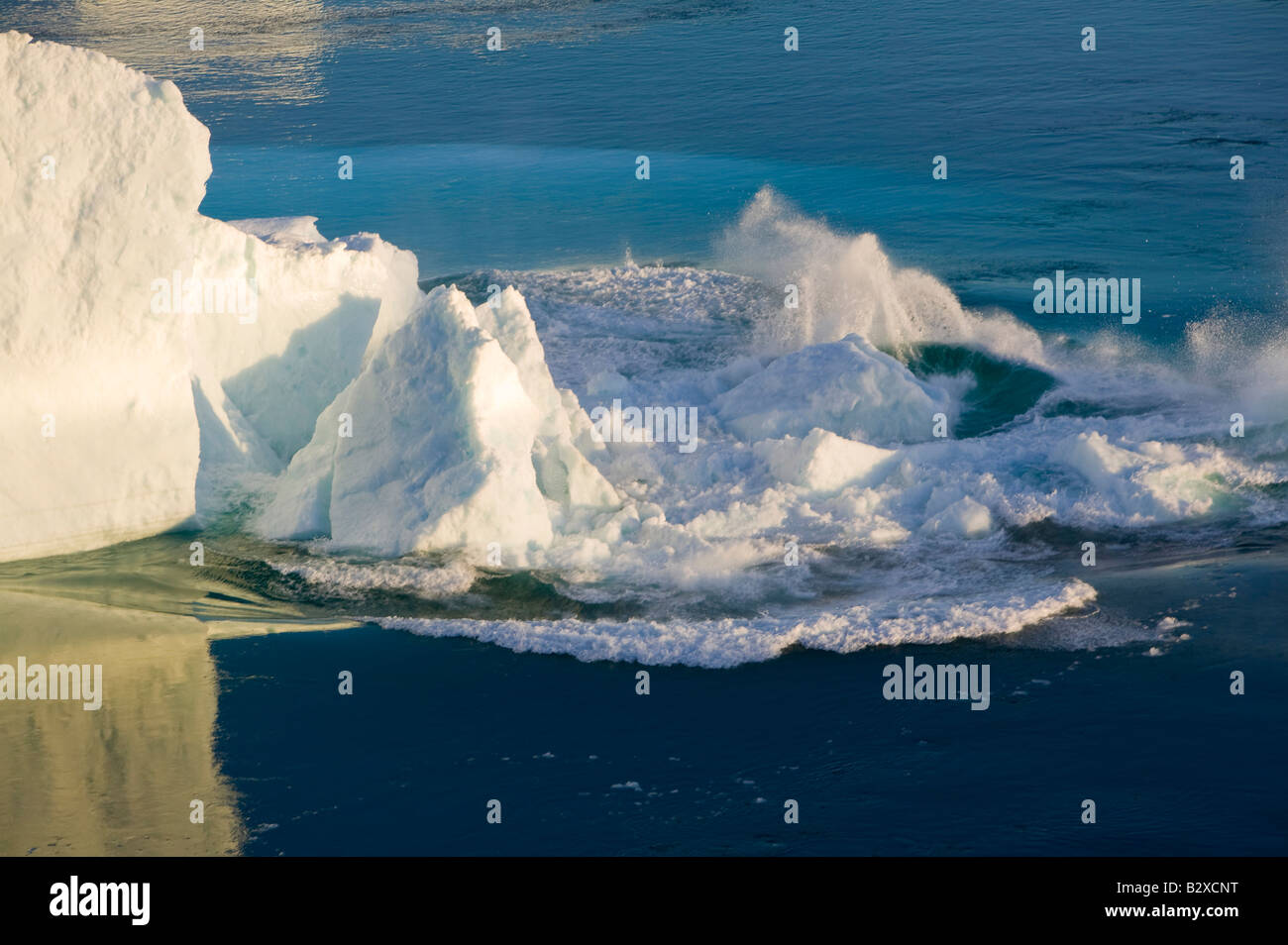An arched Iceberg collapsing into the sea from the Jacobshavn glacier or Sermeq Kujalleq which ...