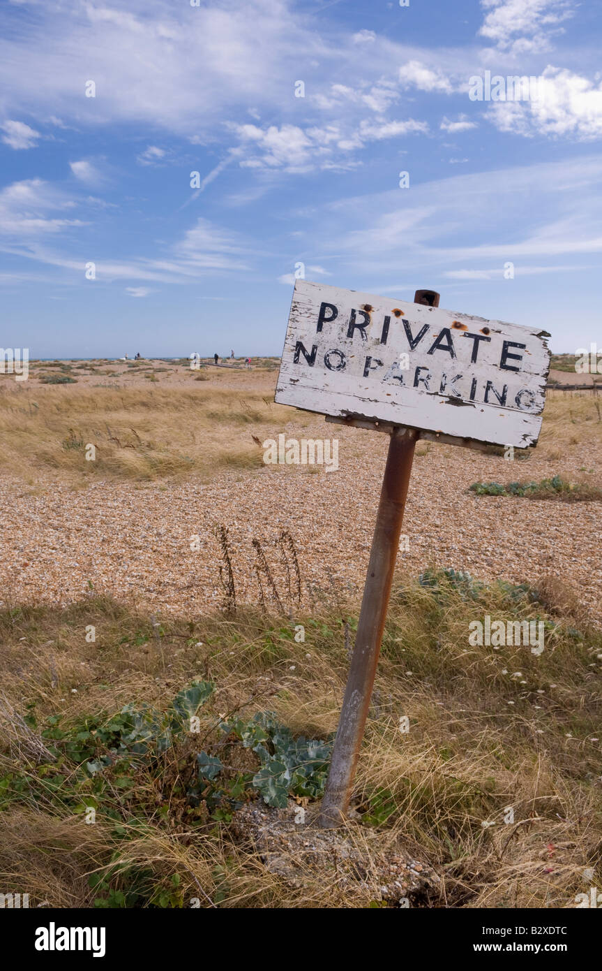 Battered and rusting old no parking sign on the shingle beach at ...