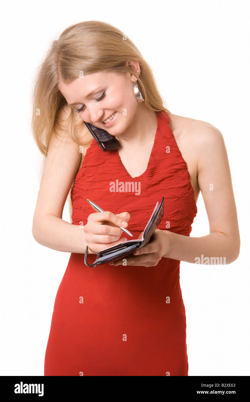 Attractive girl talk at phone and write to notebook isolated on white ...