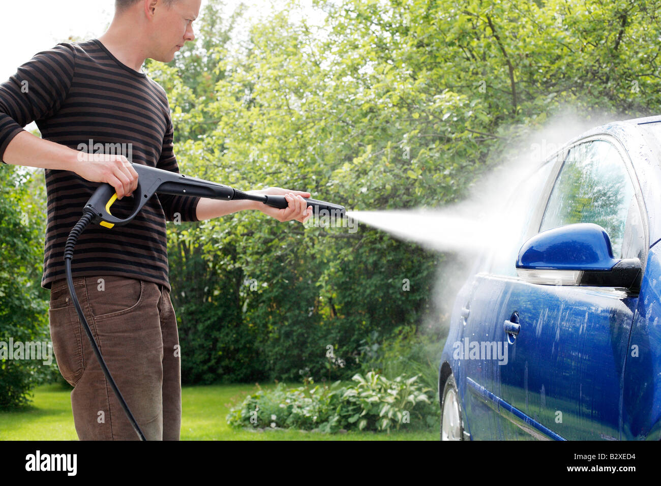 A man washing a car with a jet washer Stock Photo - Alamy