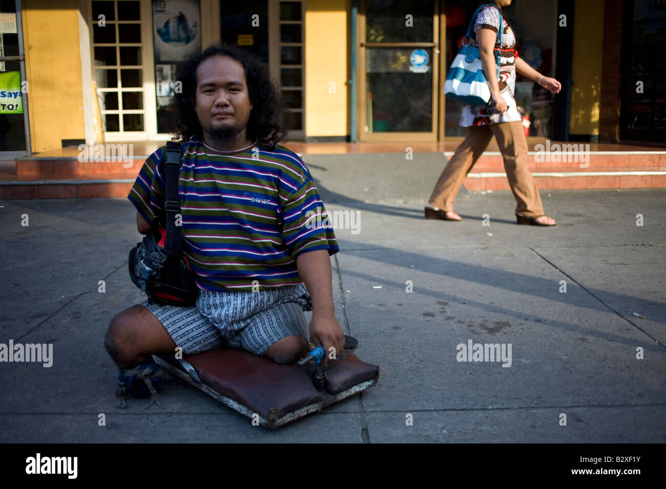 A physically handicapped Filipino begs for money on the street in ...