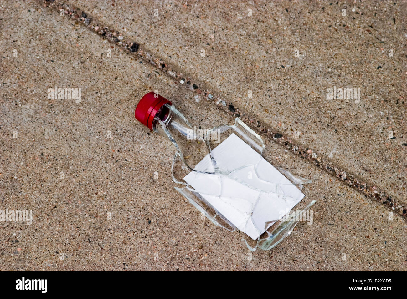 Broken glass bottle laying on the sidewalk Stock Photo - Alamy