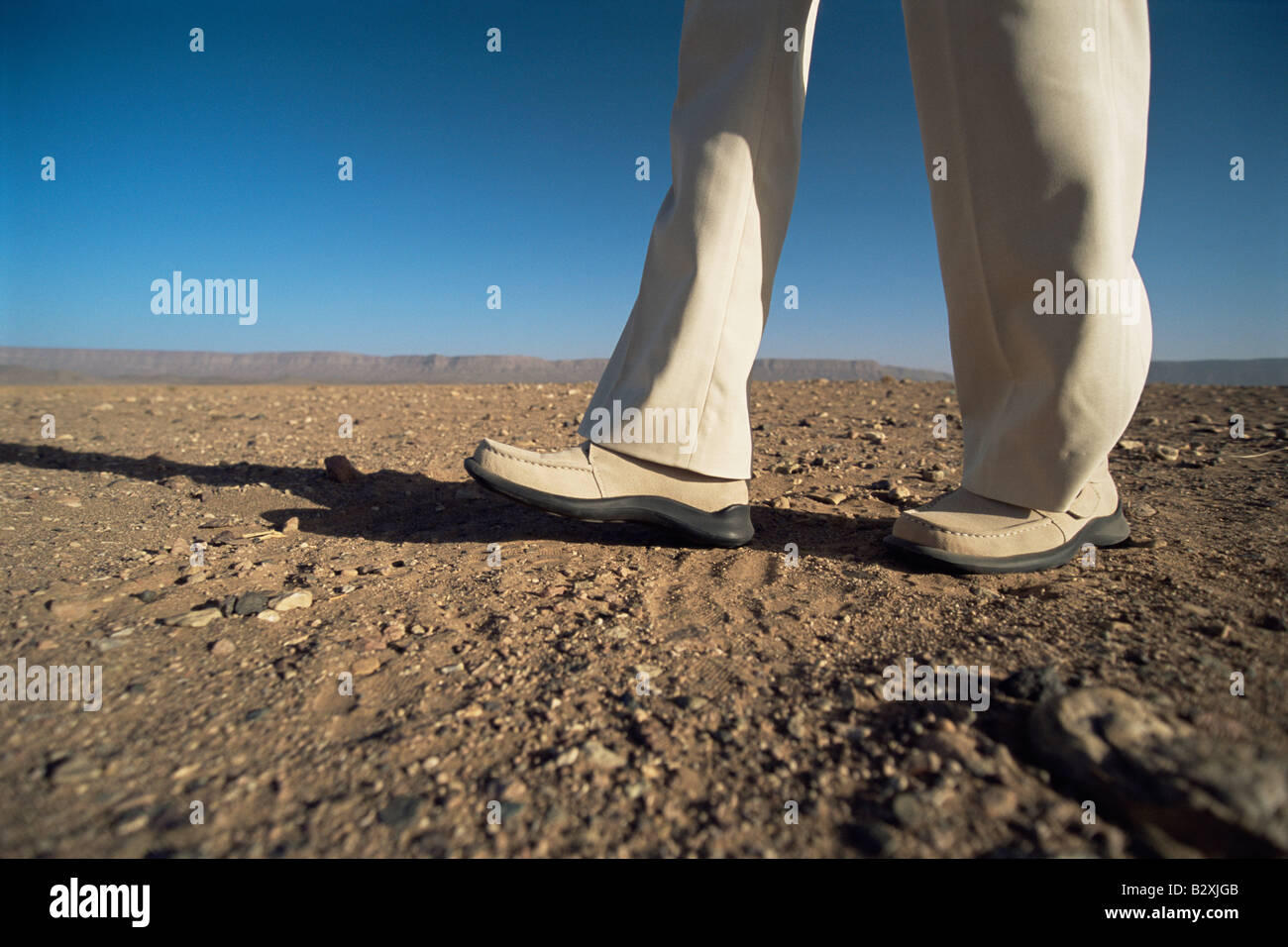 Man's legs walking through desert landscape Stock Photo - Alamy