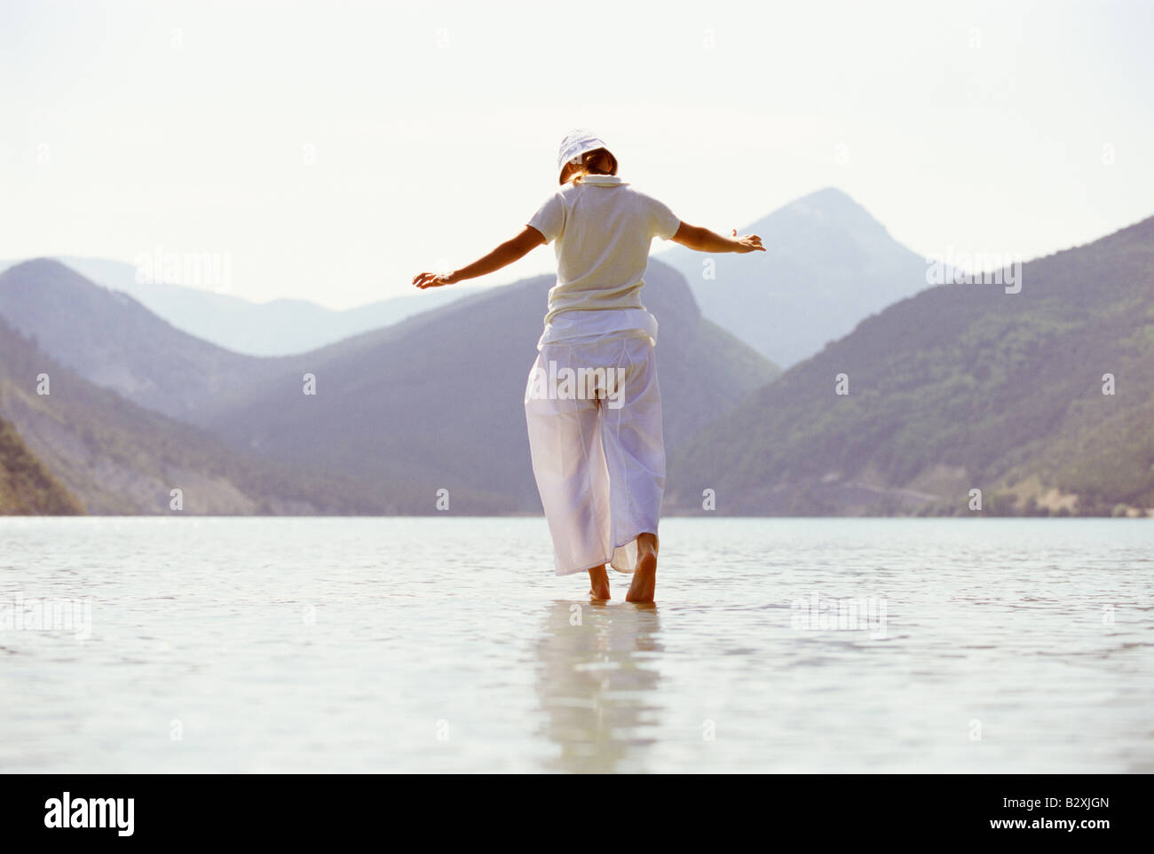 Woman outdoors walking on water in scenic location Stock Photo - Alamy
