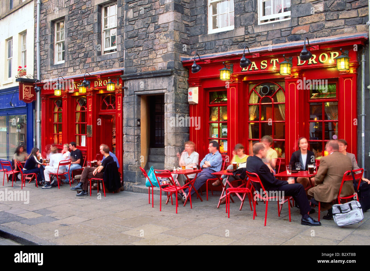 People at sidewalk tables at old pubs along Grassmarket in Edinburgh ...