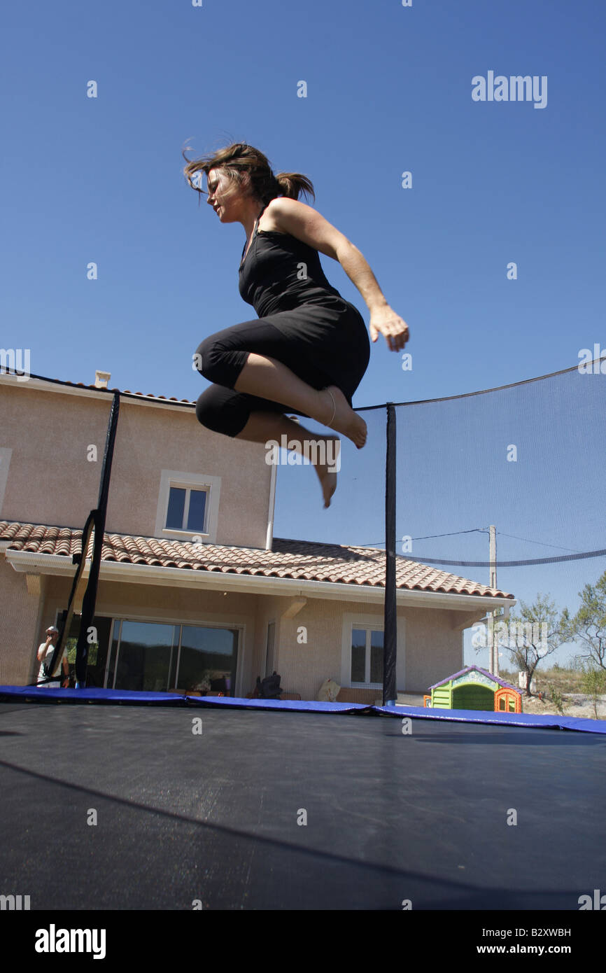 Girl jumping on trampoline, blue sky, vertical format.85078 Parnoufete ...