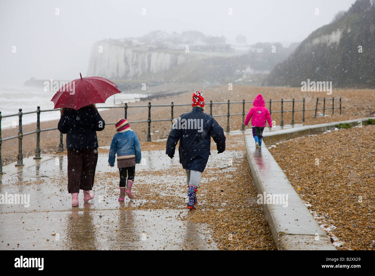 Lady walk umbrella beach rain hi-res stock photography and images - Alamy