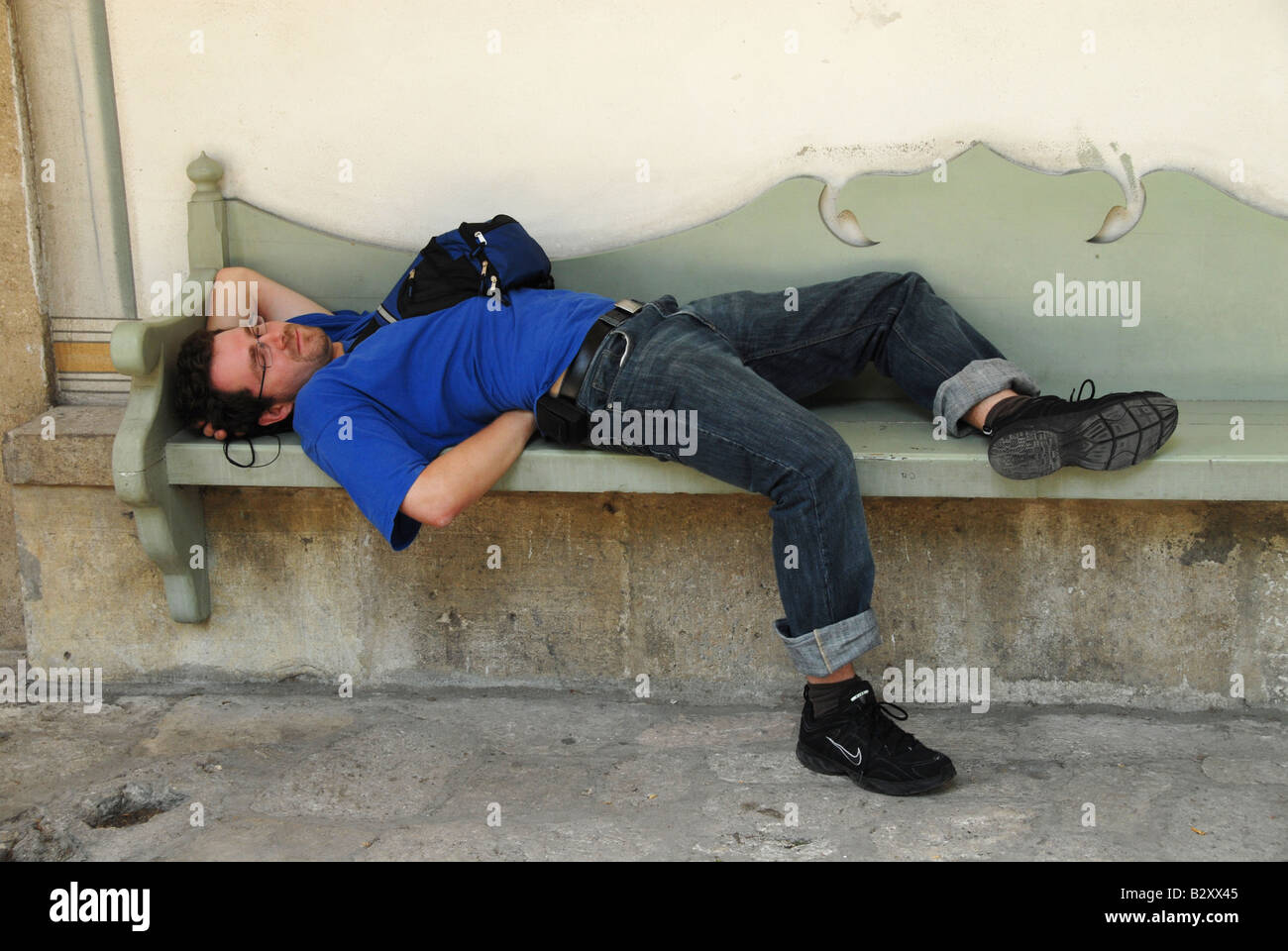 man sleeping on a bench Stock Photo - Alamy
