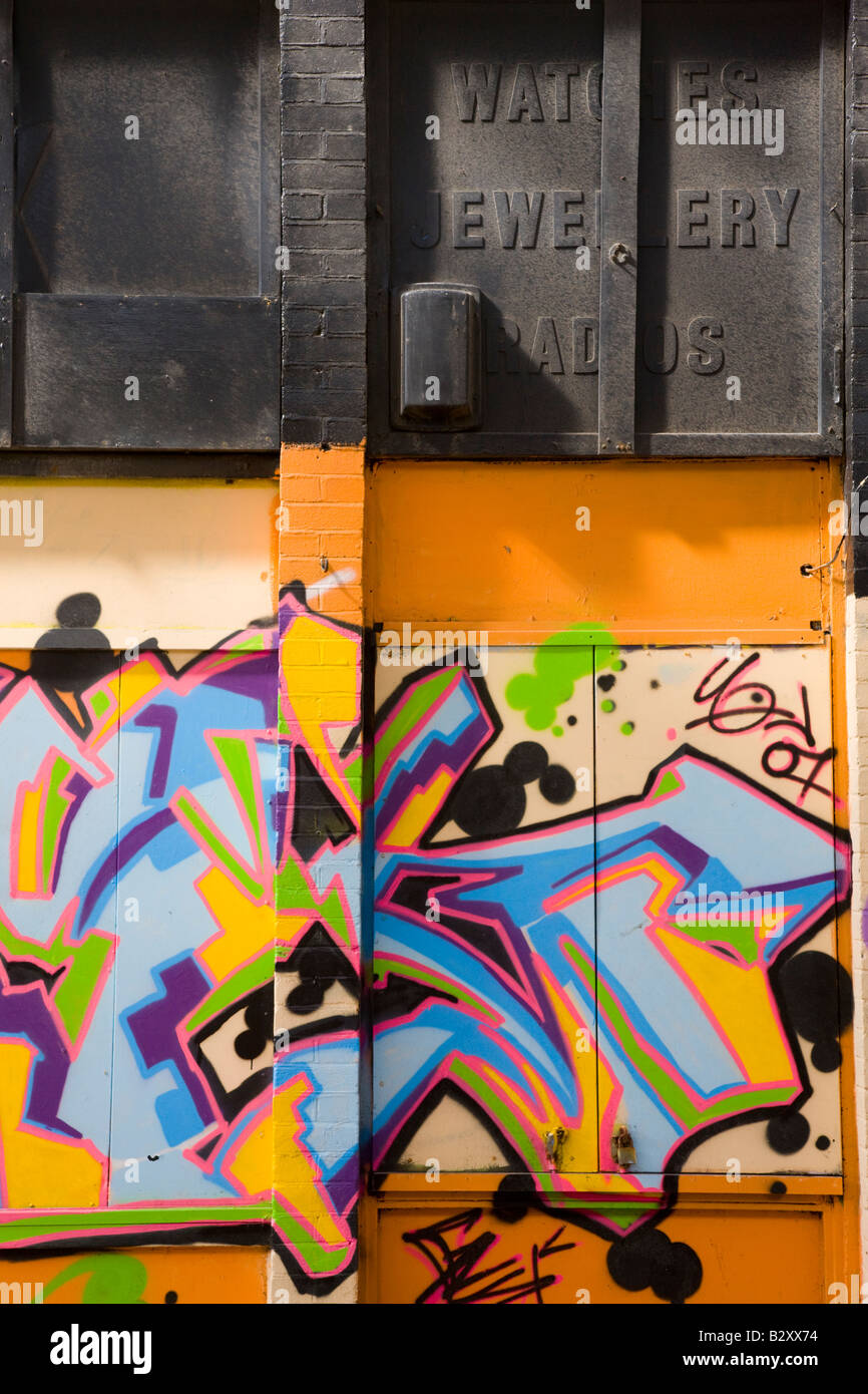 Graffiti on arcade of shops underneath a tower block of flats in ...