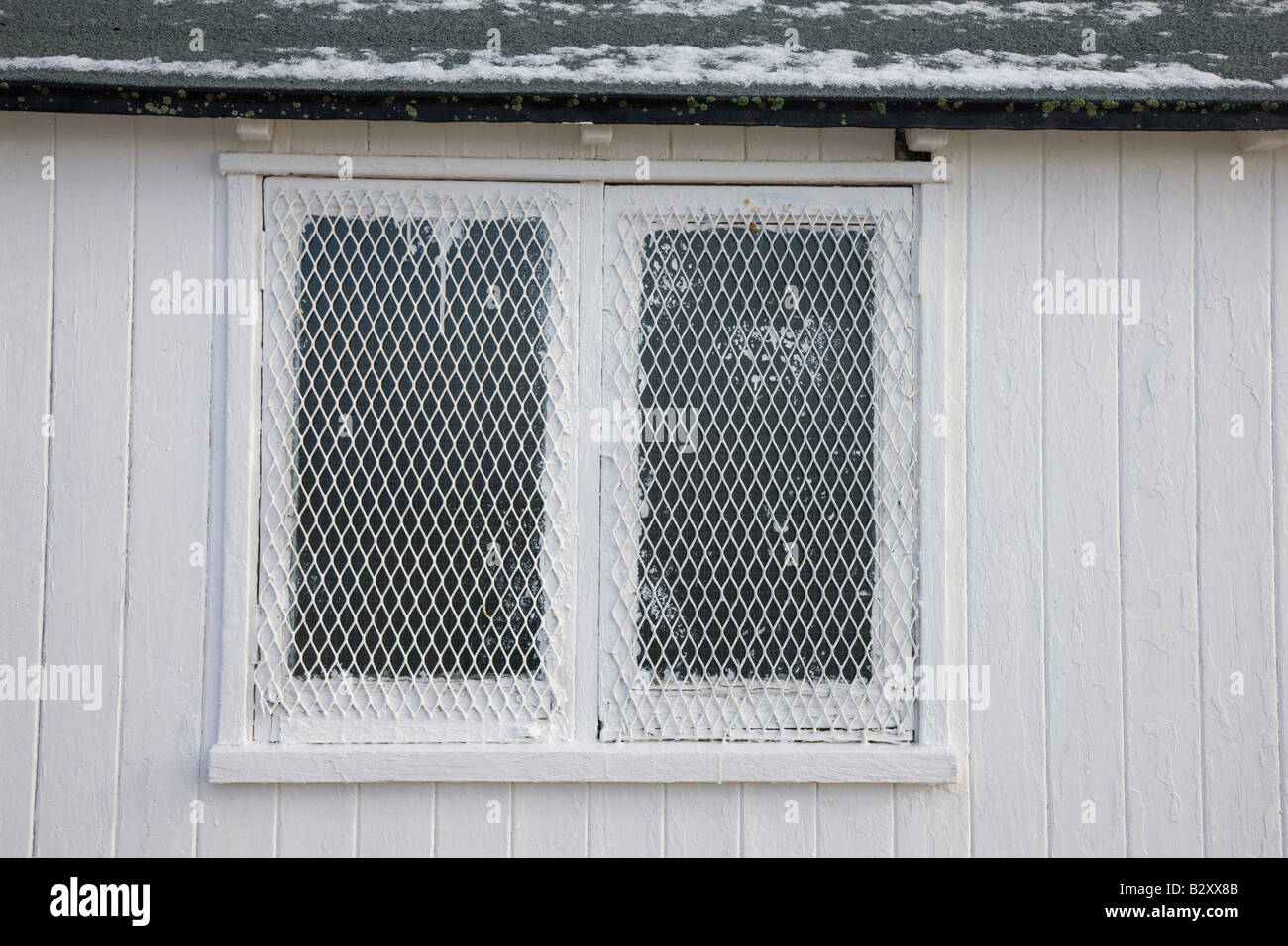Beach hut window with wire mesh cover Stock Photo - Alamy